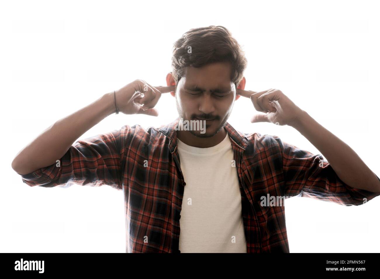 Young indian man putting fingers in ears and don’t want to listen ...