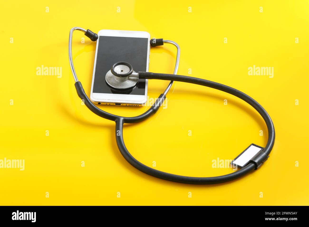 Smartphone and stethoscope on yellow background. Online medicine ...