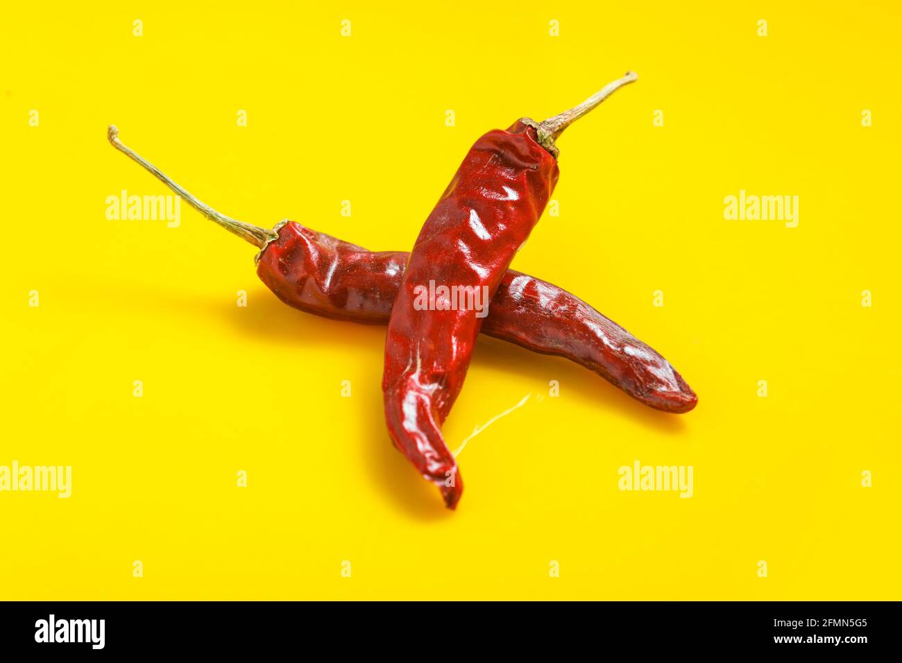 Dry Red chilli on yellow background Stock Photo - Alamy