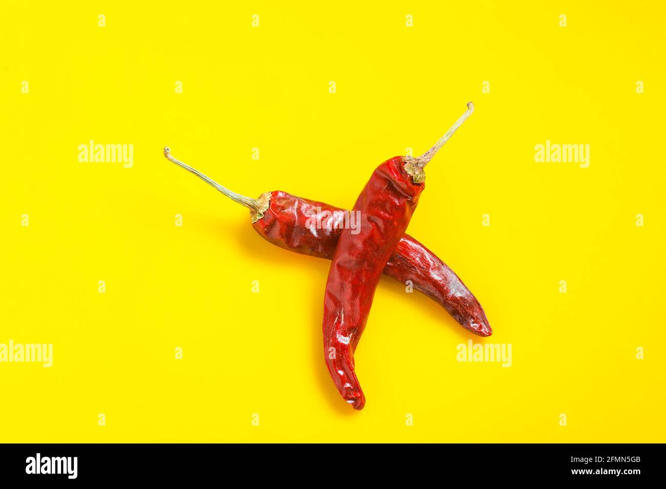 Dry Red chilli on yellow background Stock Photo - Alamy
