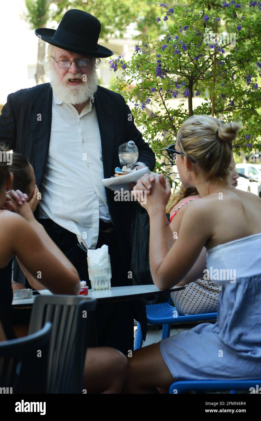 An Orthodox Jewish Israeli man approaching secular Israeli women in an ...