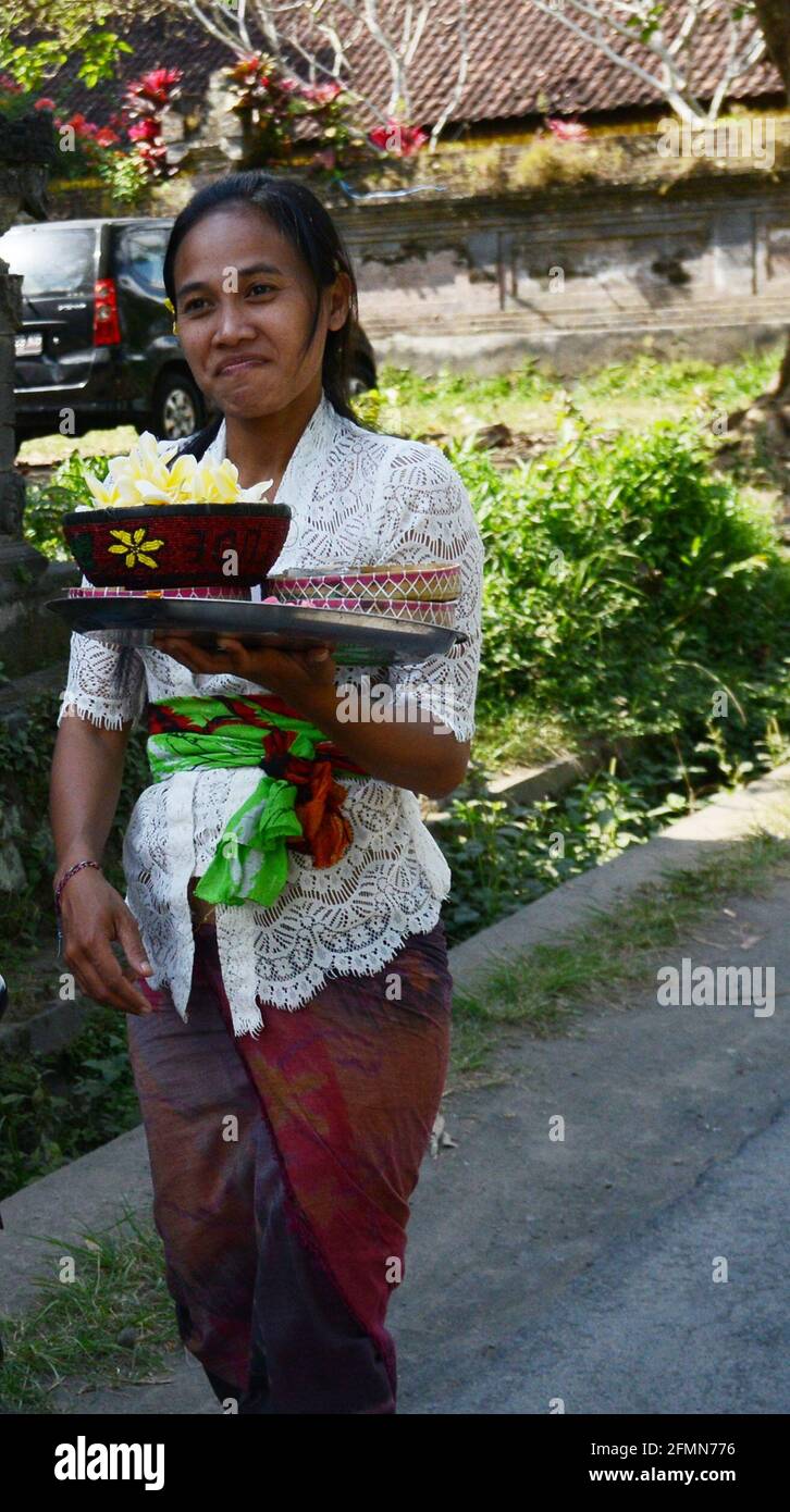 A Balinese woman holding offerings at a temple in Ubud, Bali, Indonesia ...