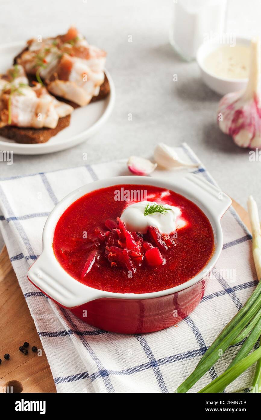 Delicious fresh red borscht, dark bread with lard and salt on kitchen ...