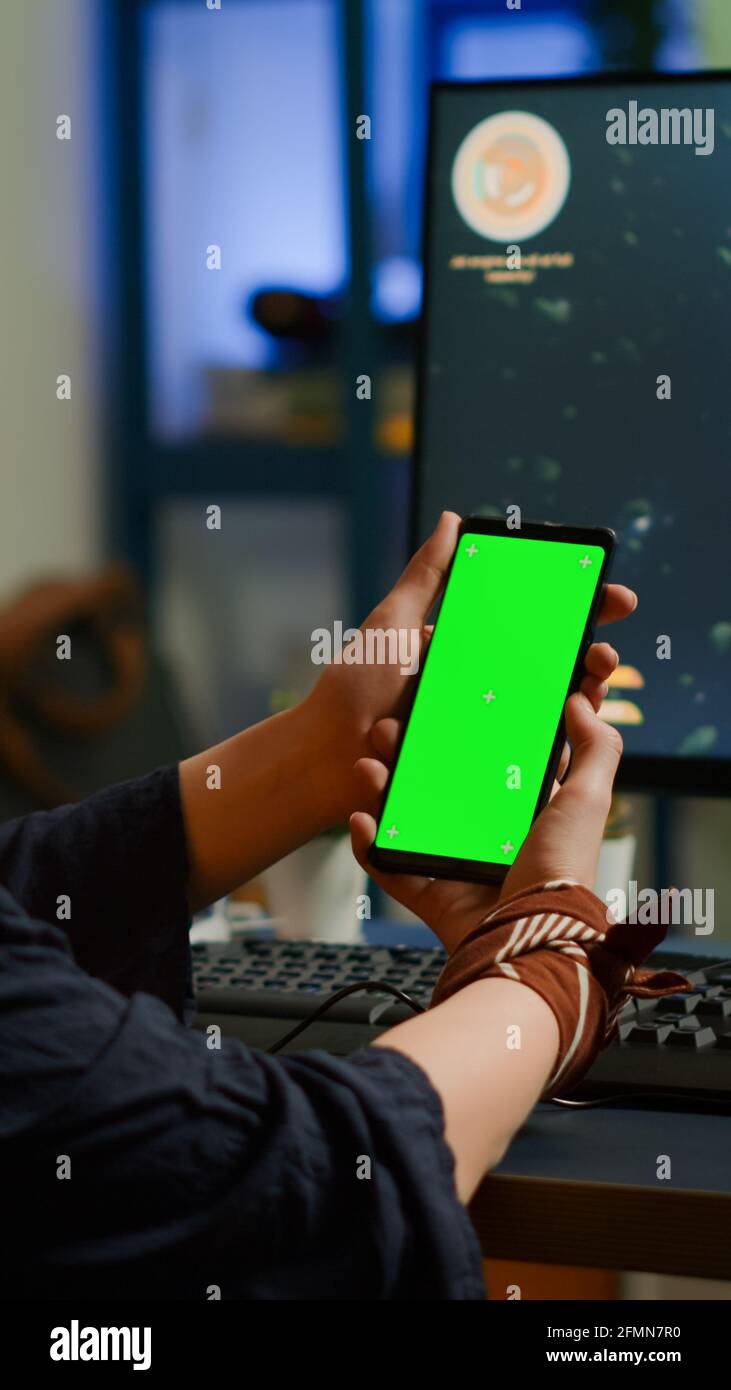 Professional cyber gamer looking at phone with greenscreen, chroma key ...