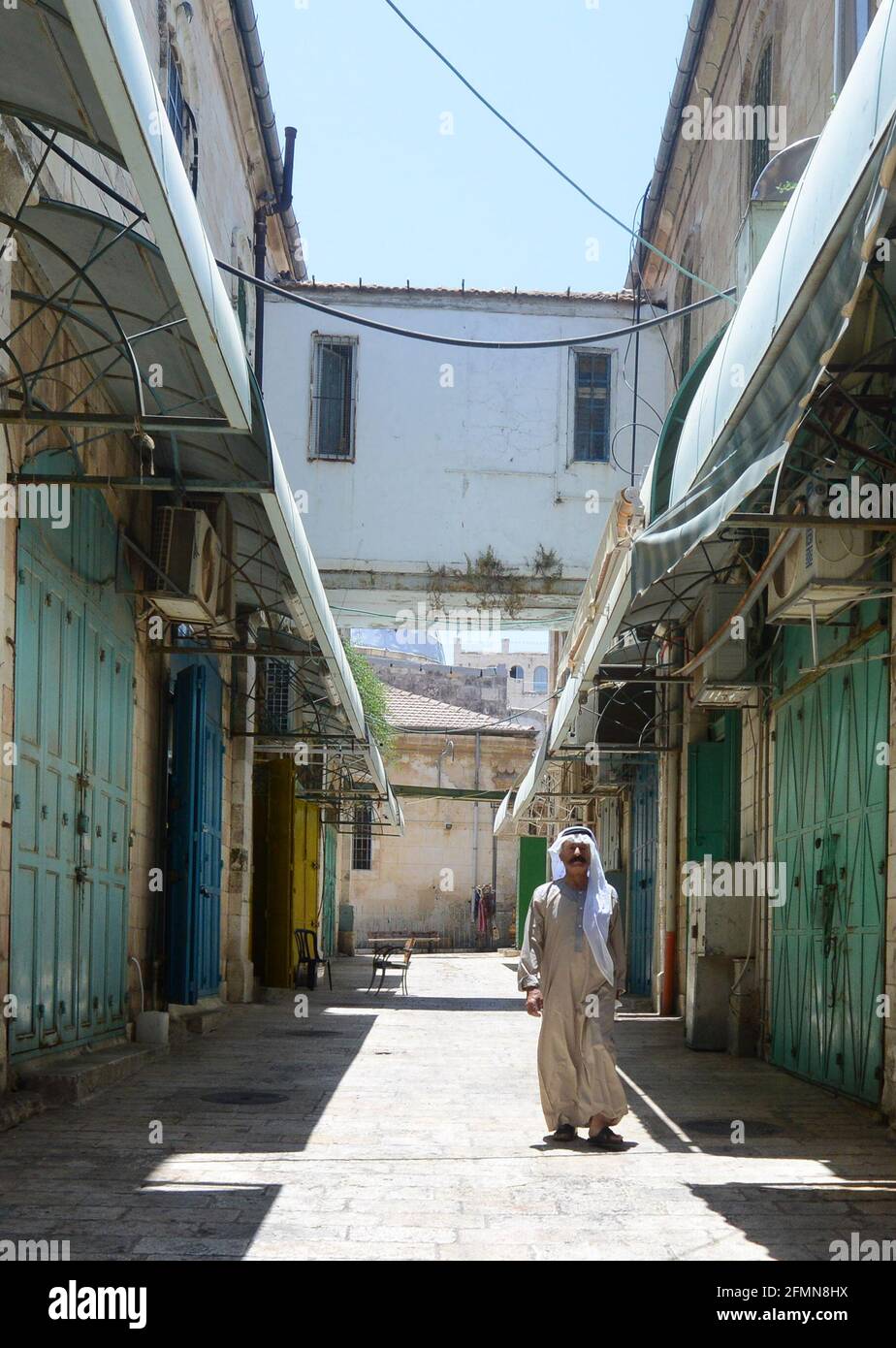 An Arab man dressed in traditional clothing walking in the Christian ...
