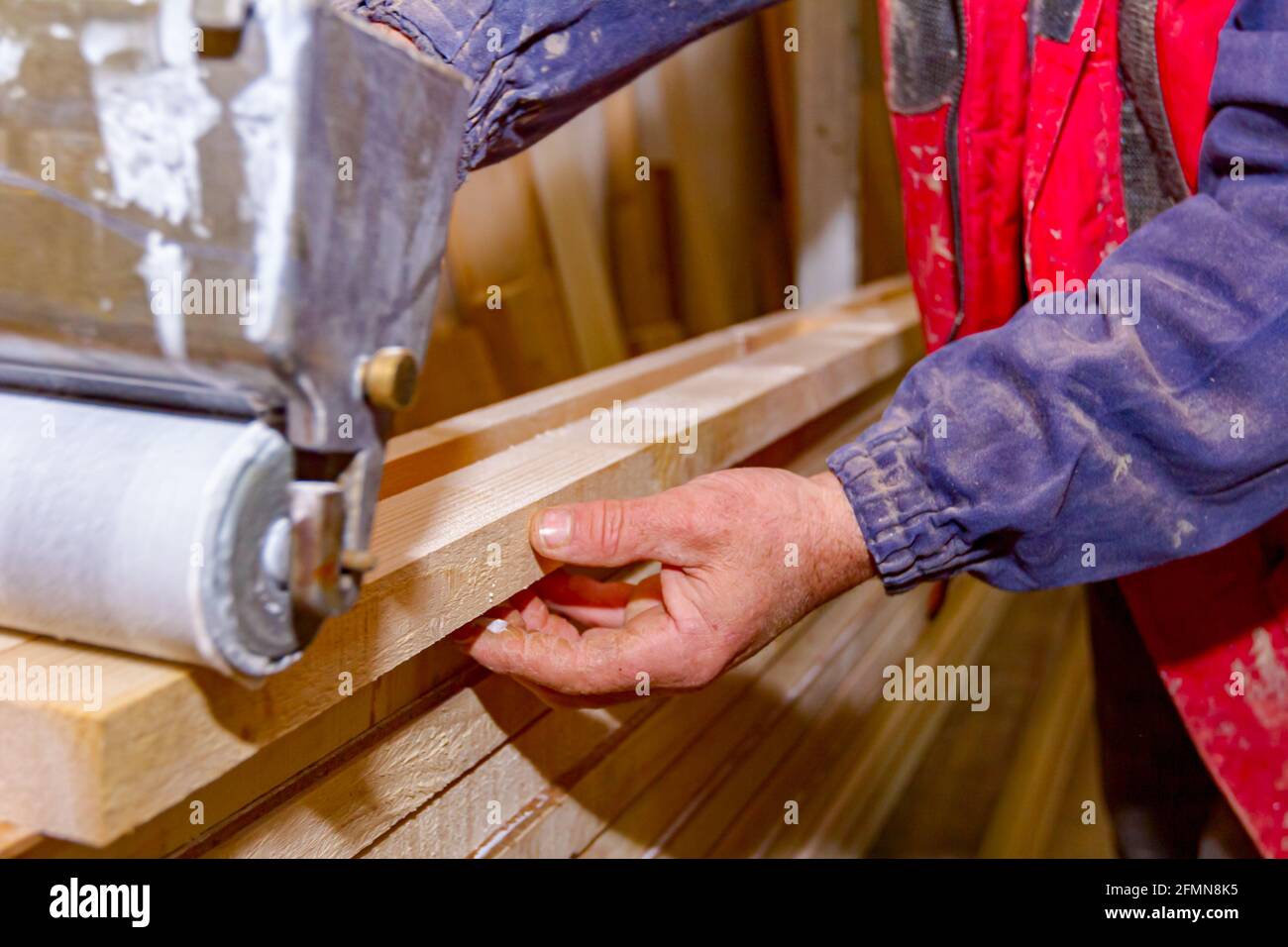 Carpentry worker uses handy roller tool, spreader for applying adhesive ...