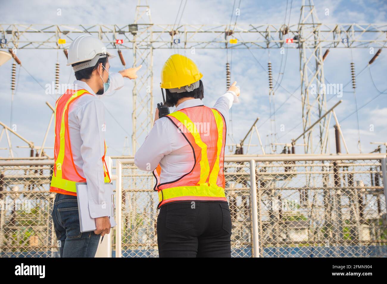 Man and Women Engineering standing communication at power plant ...