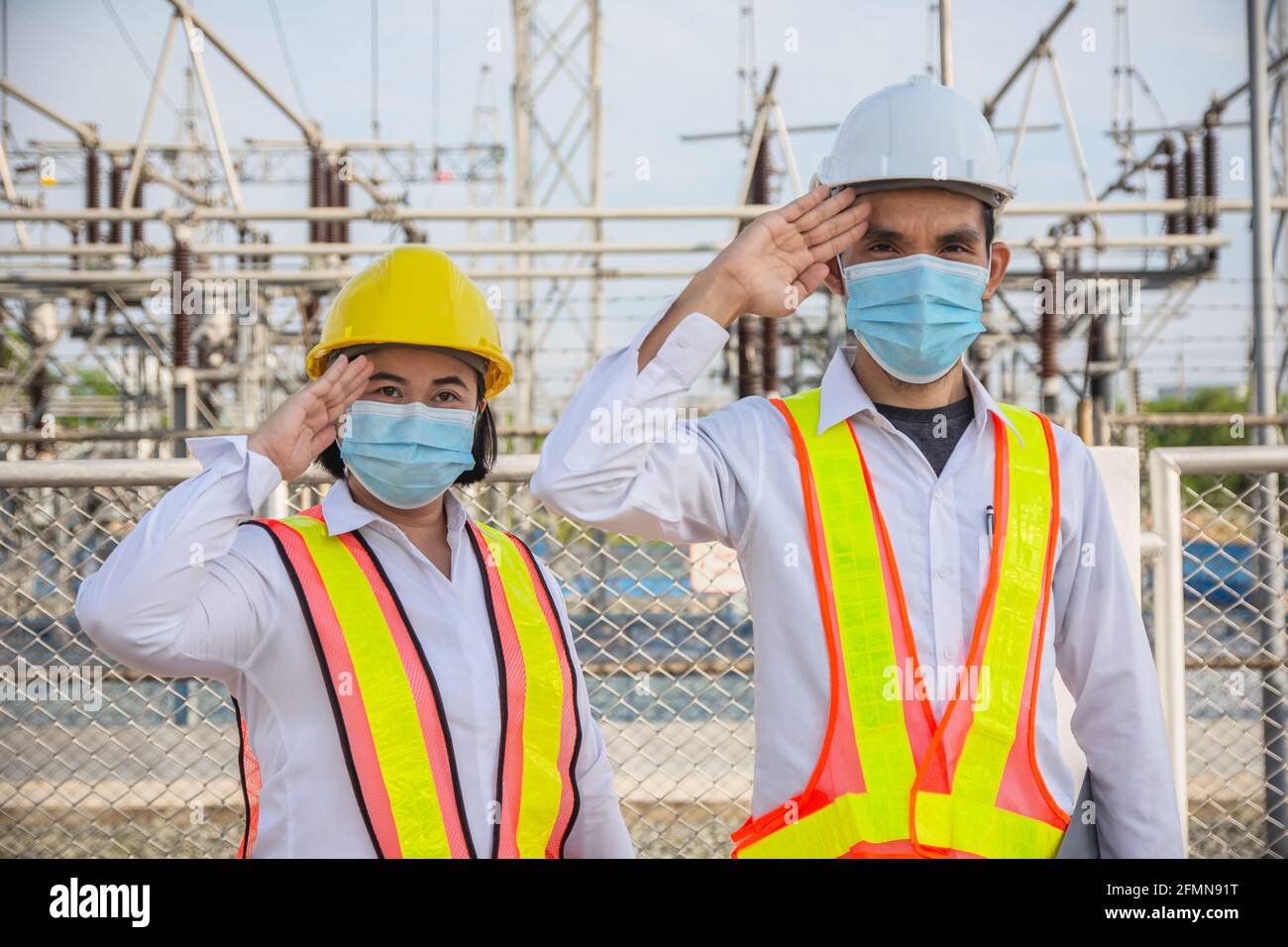 Two Engineer wear facemask teamwork are working industrial electricity ...