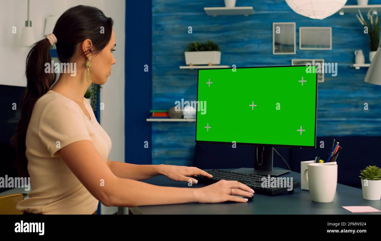 Caucasian female at her desk working on personal computer with mock up ...