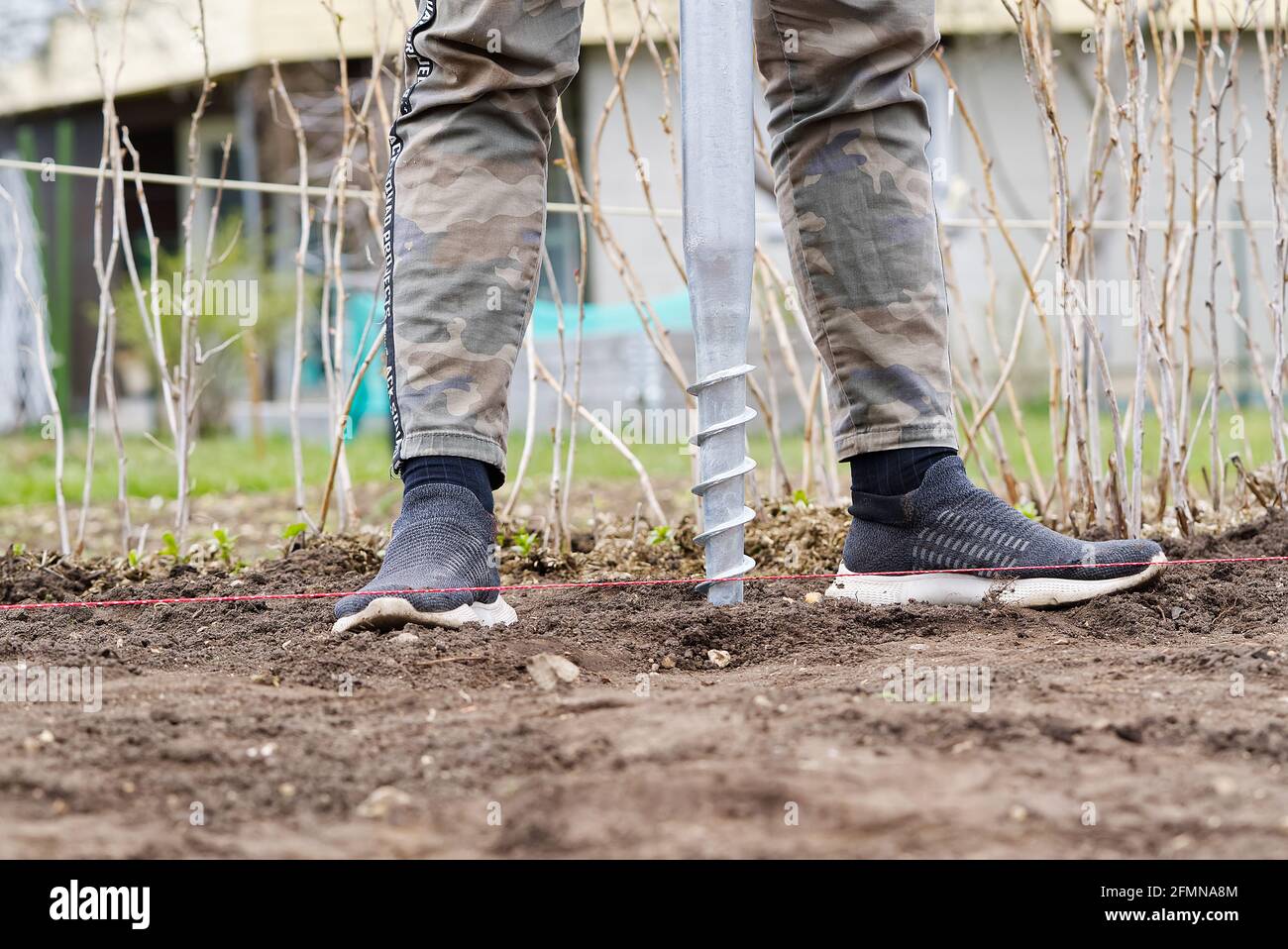 the builder twists the foundation made of screw piles. Lightweight and ...