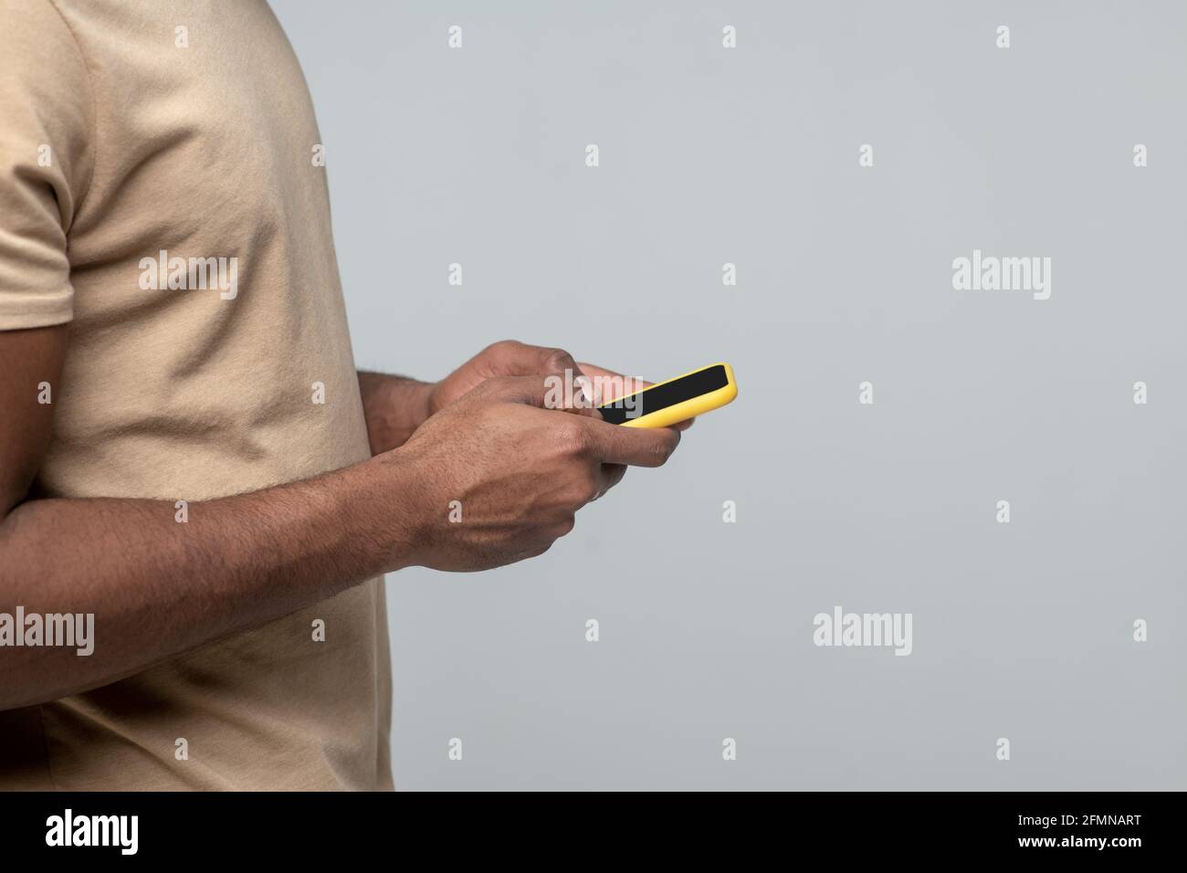 Hands of man standing sideways with smartphone Stock Photo - Alamy