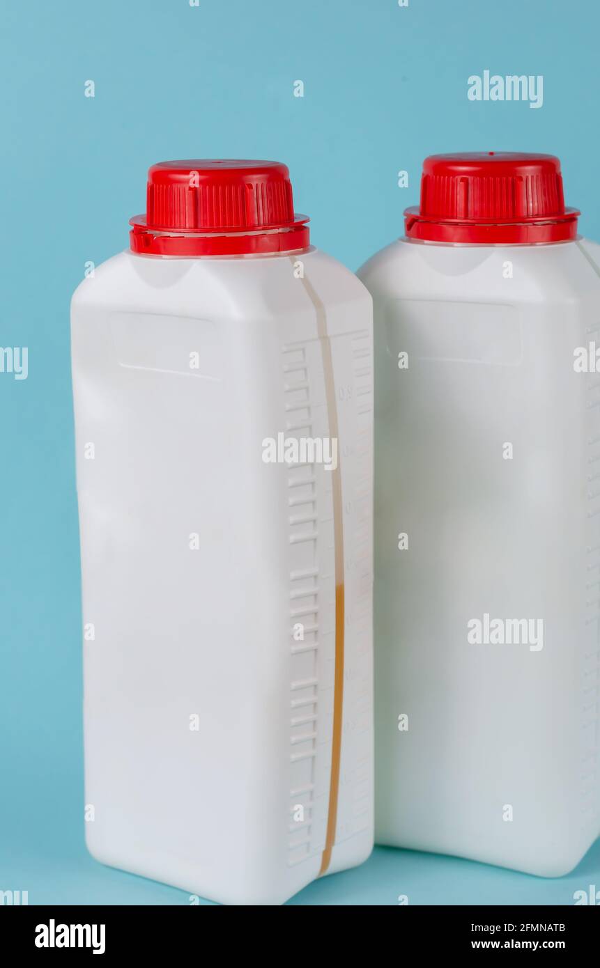 Two white containers with lid for liquids on blue background ...