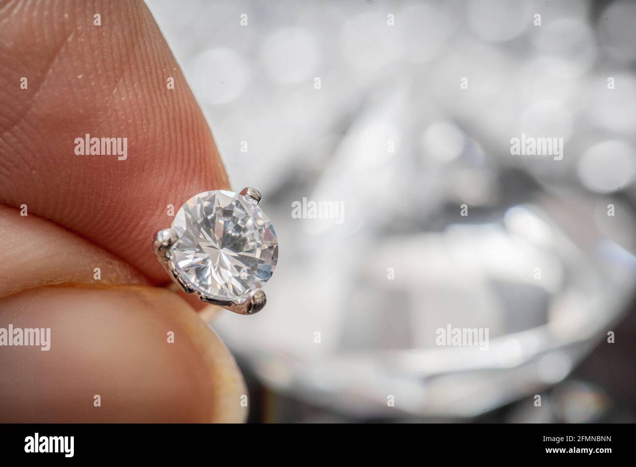 Hand is holding brilliant or diamond gem on black background Stock ...