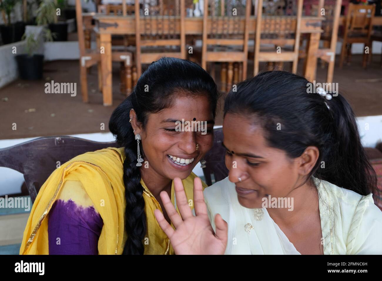 Shallow focus of two Indian women looking at something with smiling ...