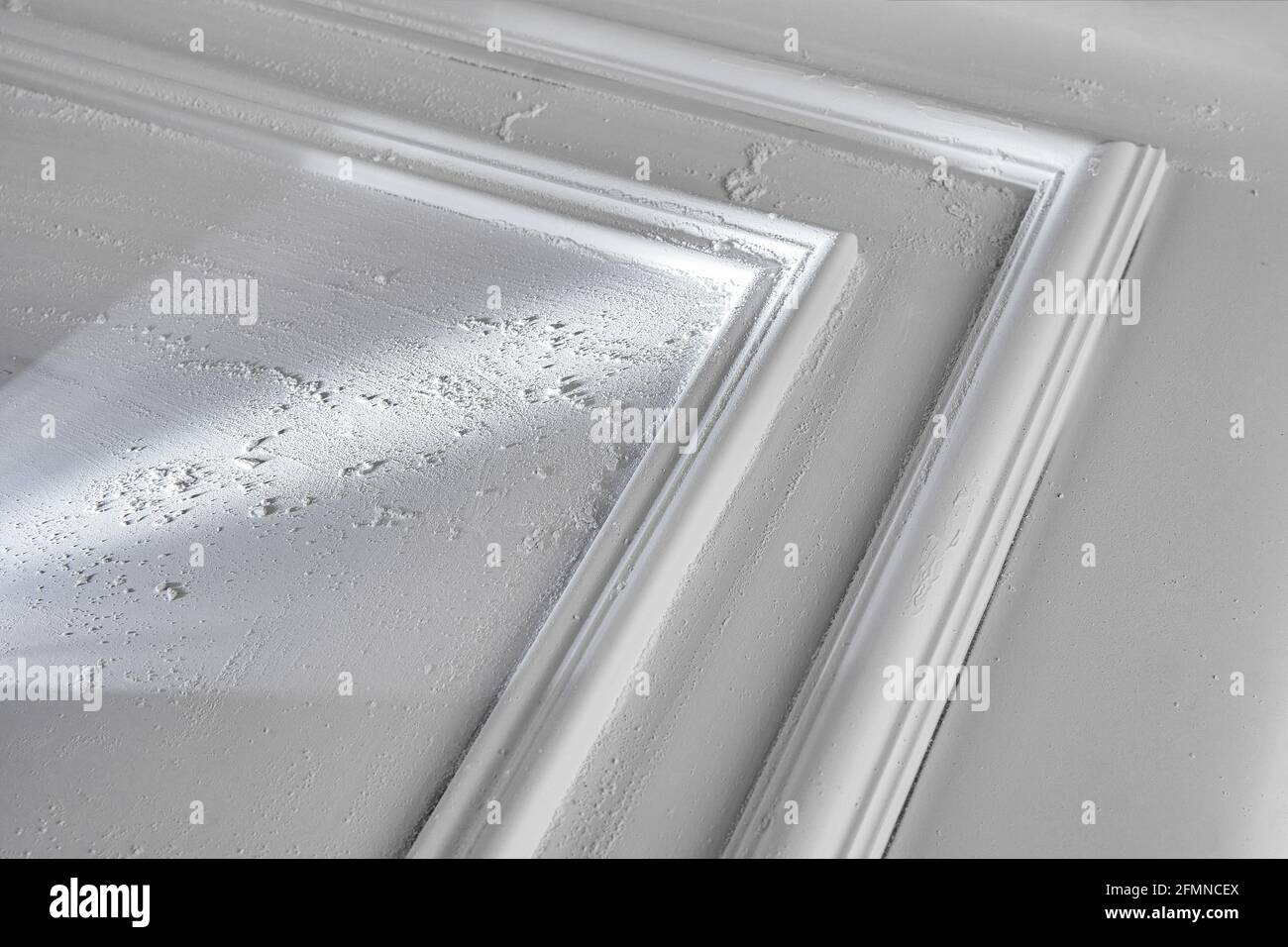 Dust and shavings on sanded down white wooden panel with moldings ...