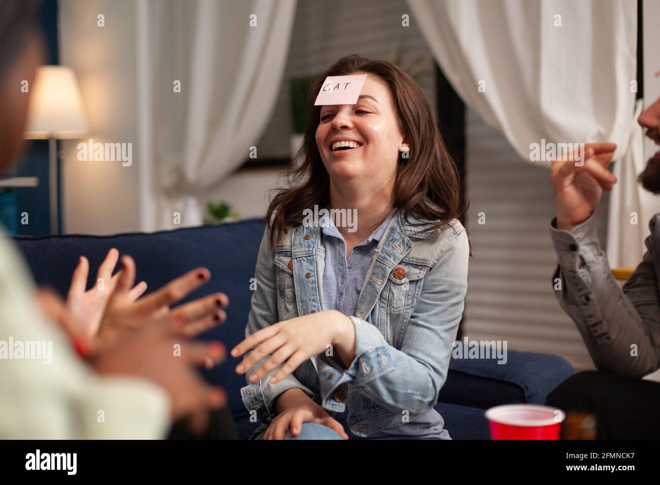Multiethnic friends having attaching sticky notes on forehead while ...