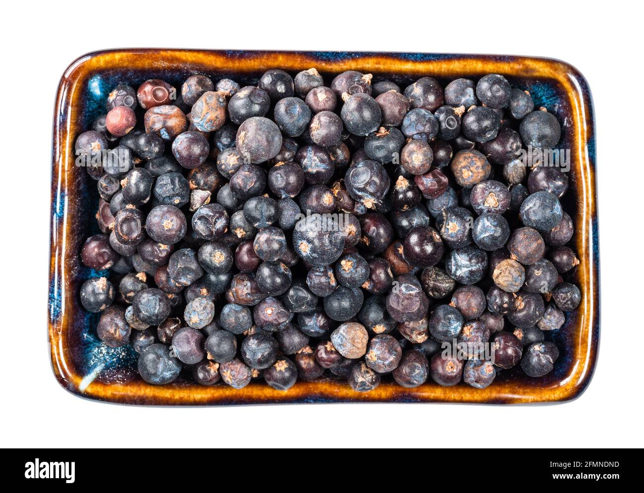 top view of dried juniper berries in ceramic bowl cutout on white ...