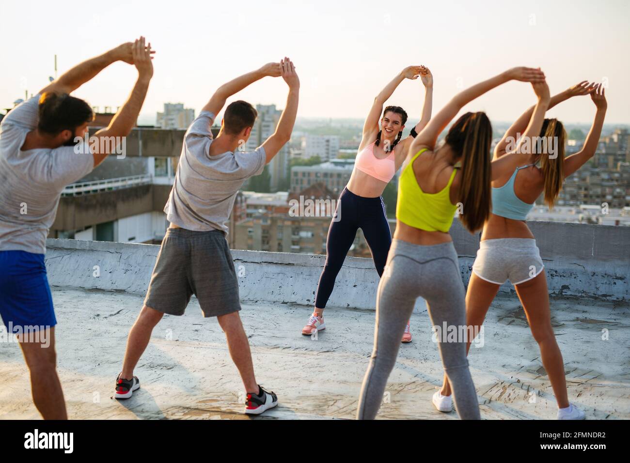 Group of happy fitness people training together outdoors, living active ...