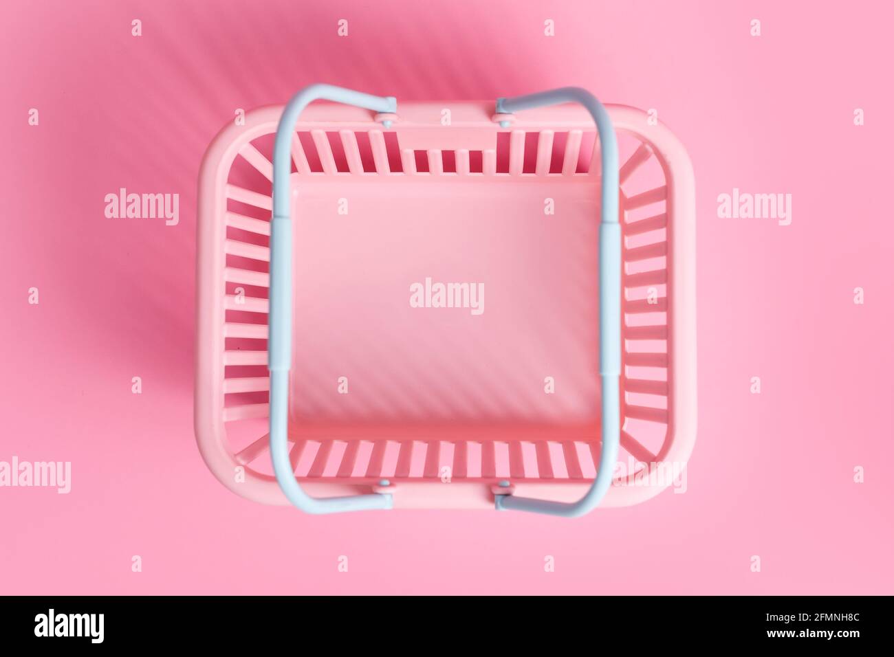 Colorful plastic shopping basket. Empty pink supermarket basket on pink ...