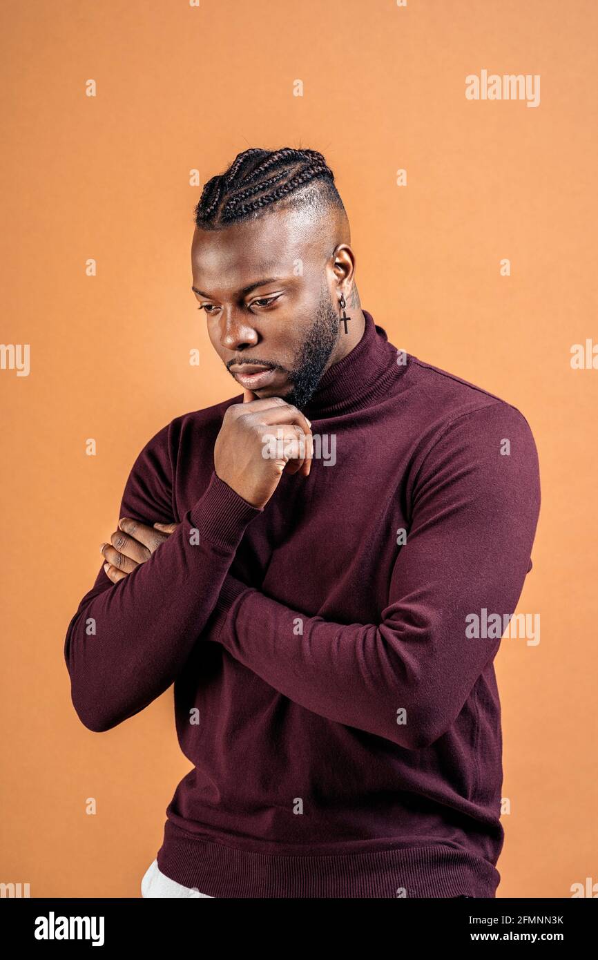 Black man with expressive eyes looking down in studio shot against ...