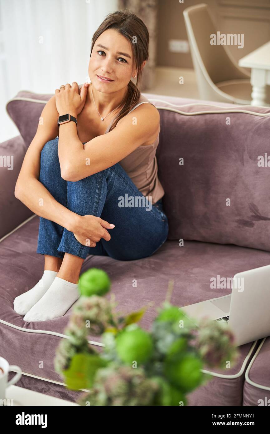 Young attractive female person embracing her knees Stock Photo - Alamy