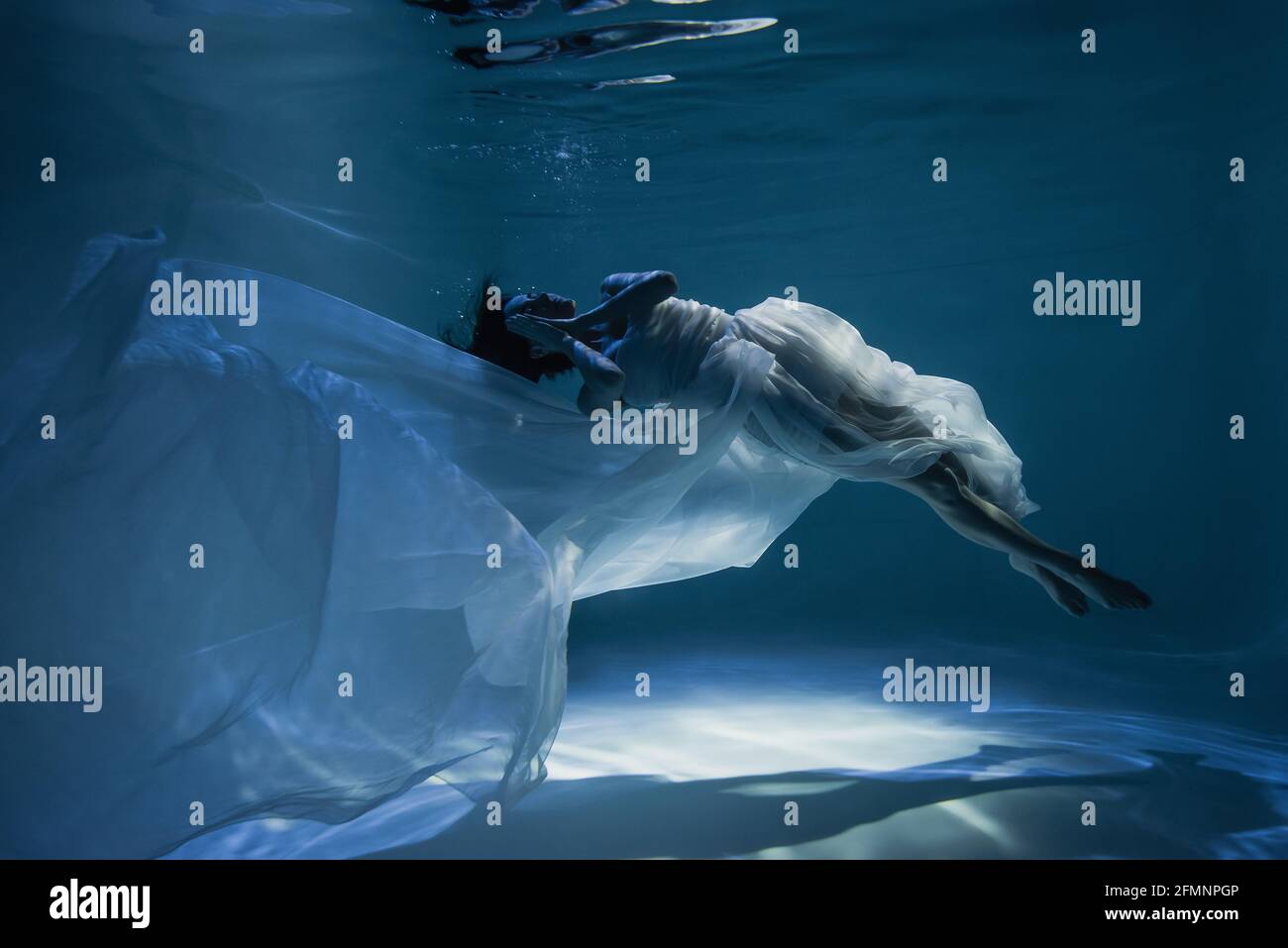 lighting on peaceful young woman in white elegant dress sleeping while ...