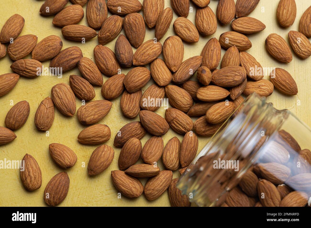 Pile of peeled raw almonds on a yellow table Stock Photo - Alamy