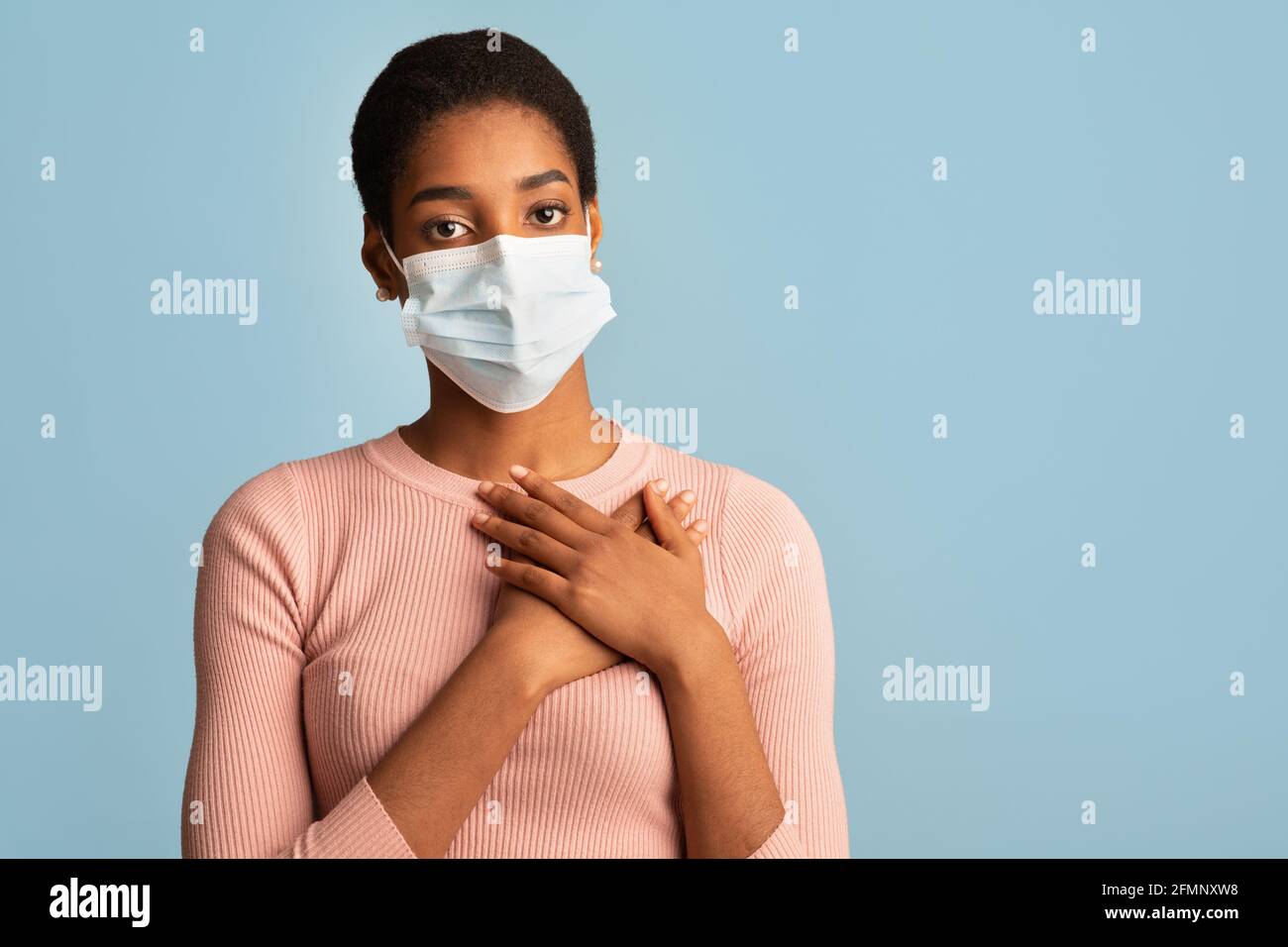 Woman holding hands to chest hi-res stock photography and images - Alamy