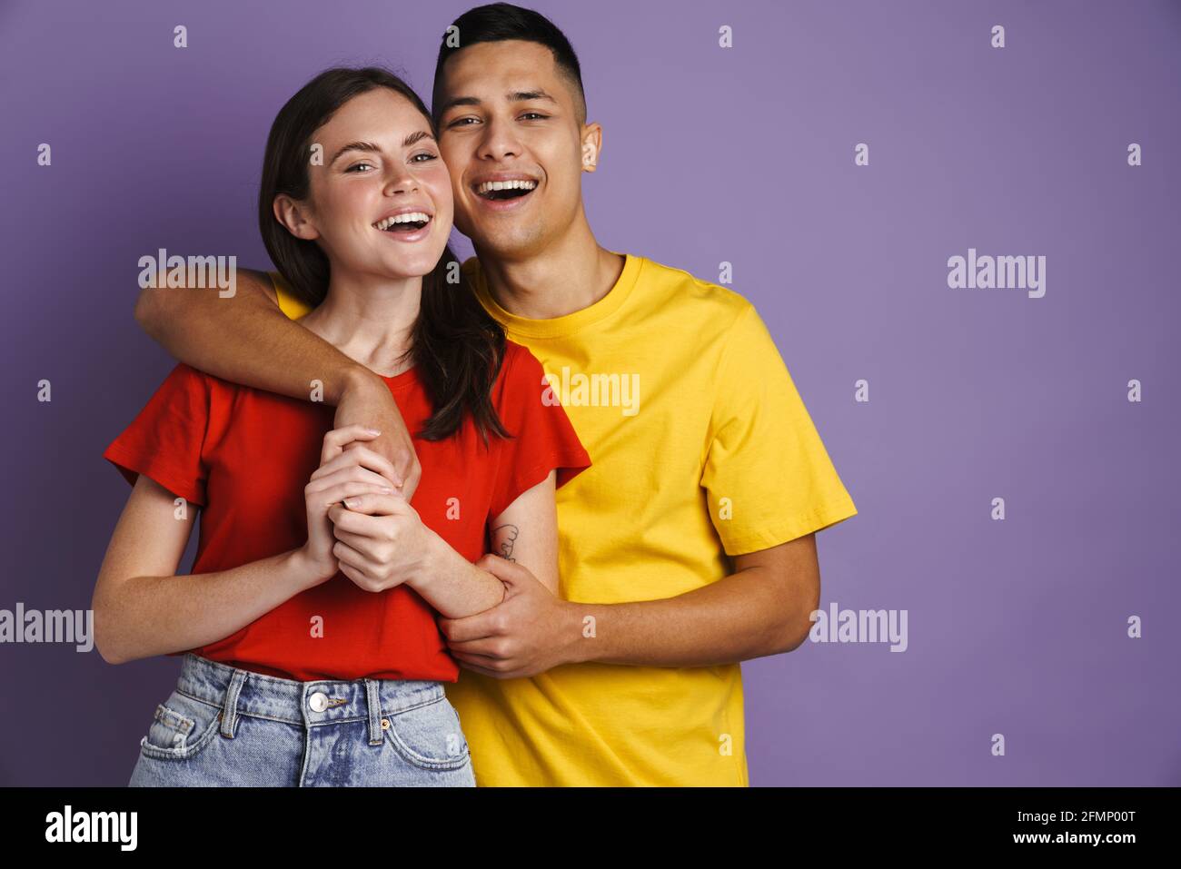 Happy beautiful couple hugging and holding hands isolated over violet ...
