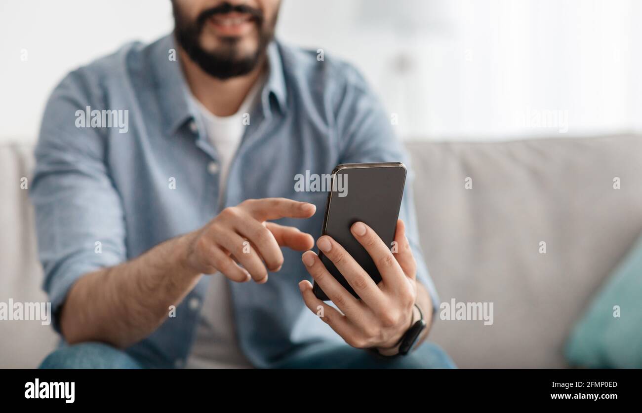 Modern smartphone in unrecognizable man hands. Guy using brand new ...