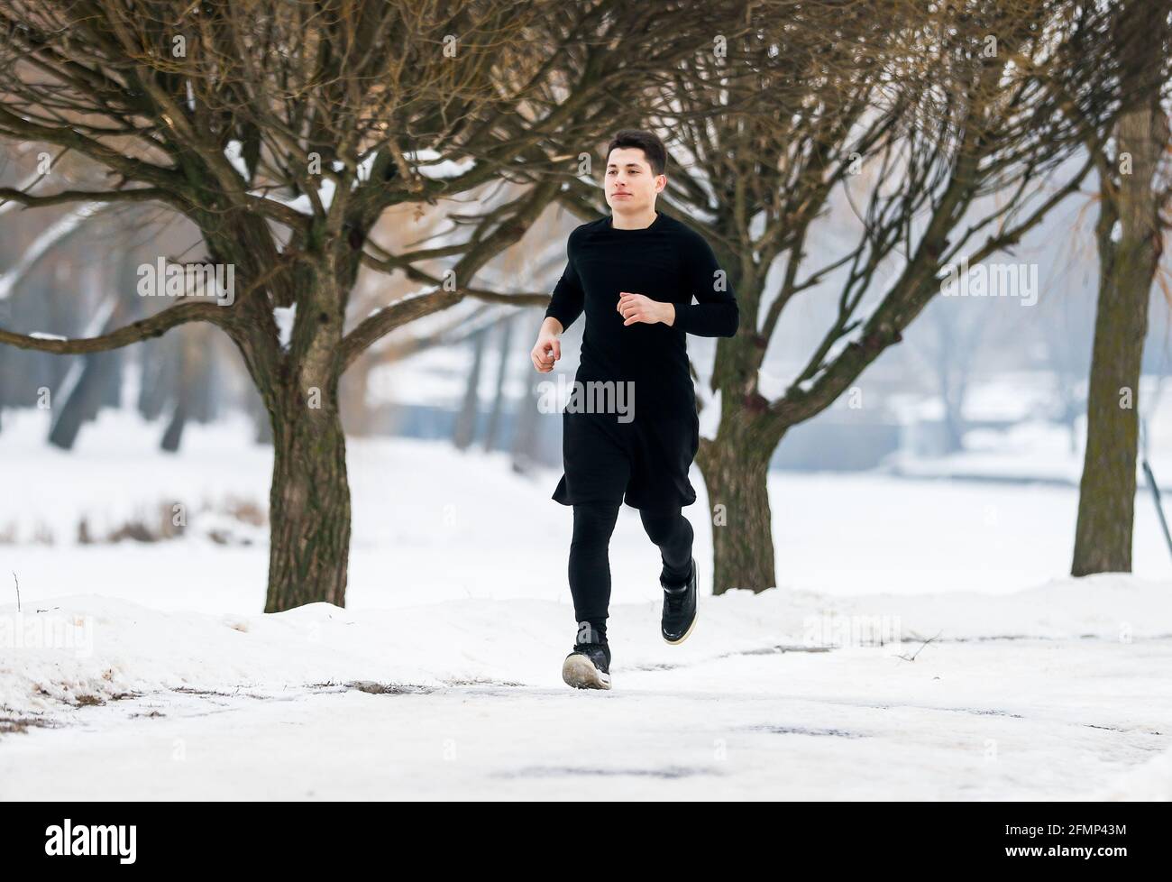 The young man goes jogging in winter while doing sports Stock Photo - Alamy