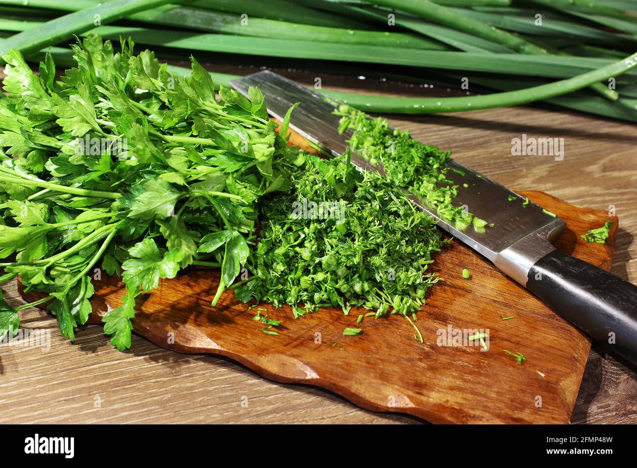 Cooking in the kitchen. Greenery. Green onions. Knife and cutting board Stock Photo - Alamy