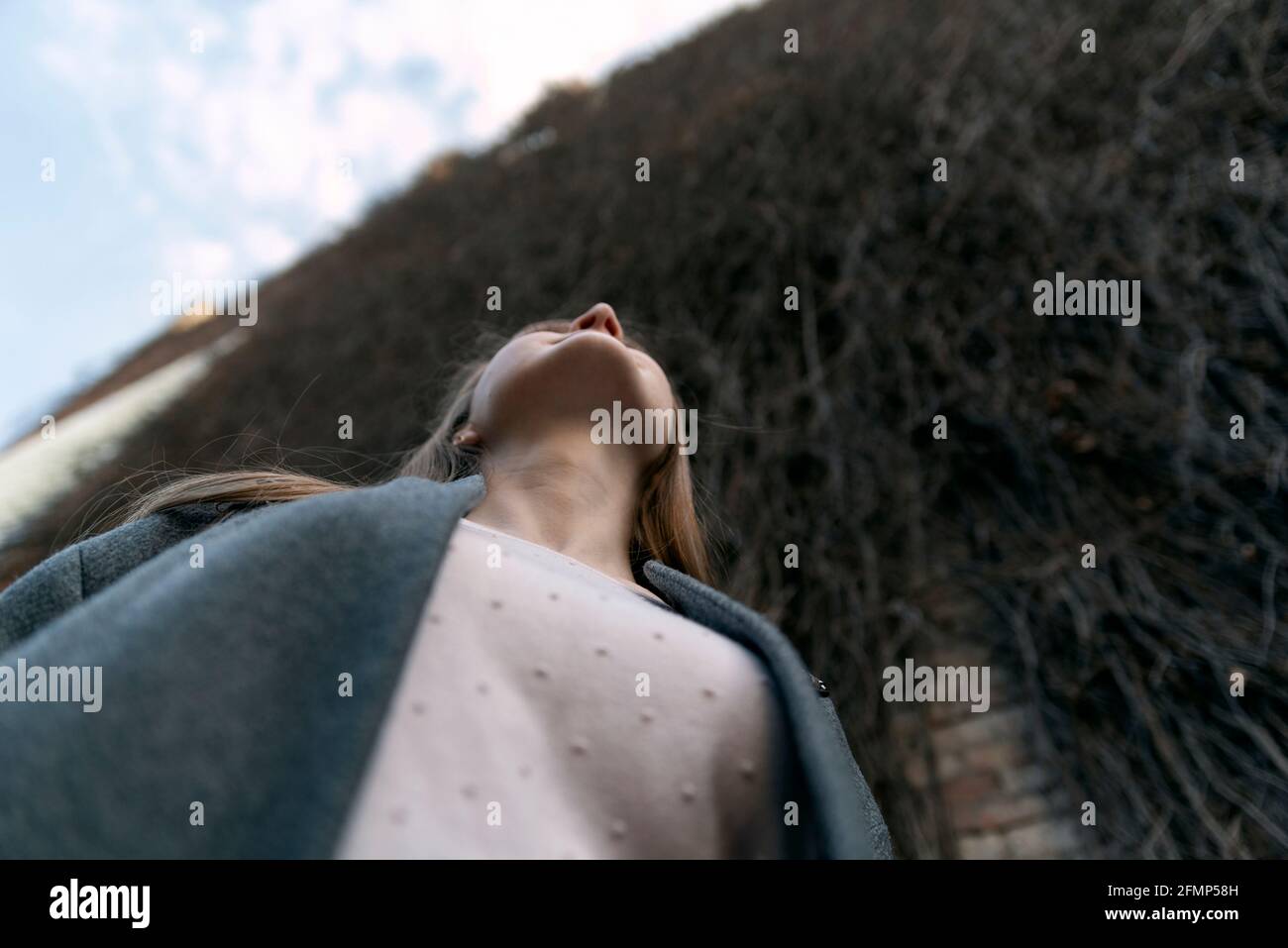 Portrait of girl bottom view. Girl walks outdoors. Blue sky and old ...