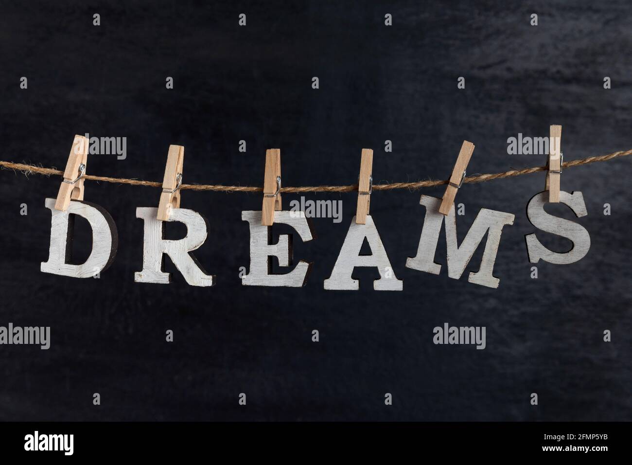 Word DREAMS with clothespins on black background. Dream visualization ...