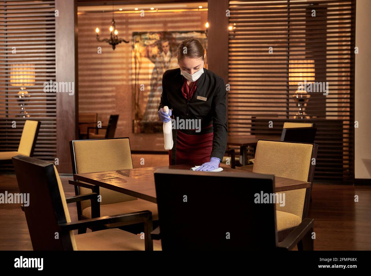 Focused female restaurant employee tidying up a table Stock Photo - Alamy