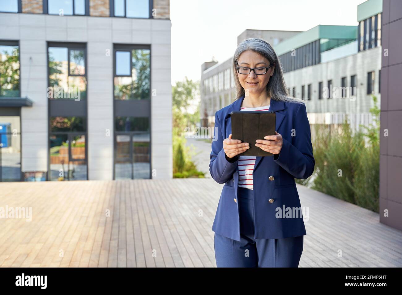 Professional female office worker standing outdoors with tablet Stock ...