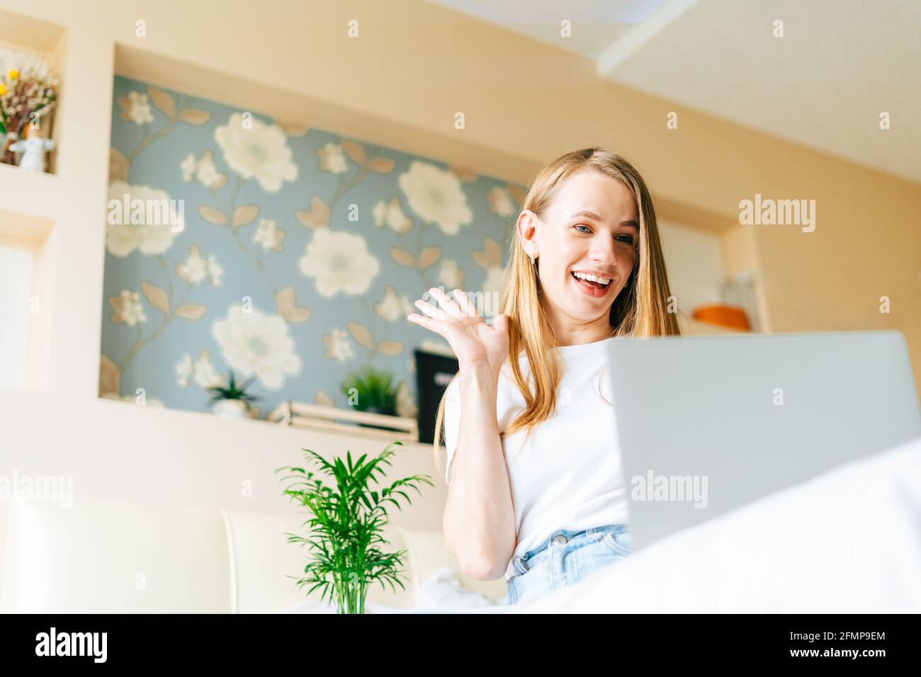 Blonde woman working at home with laptop Stock Photo - Alamy