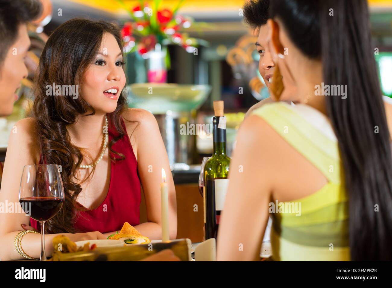 Four Asian Chinese business people having dinner in elegant club ...