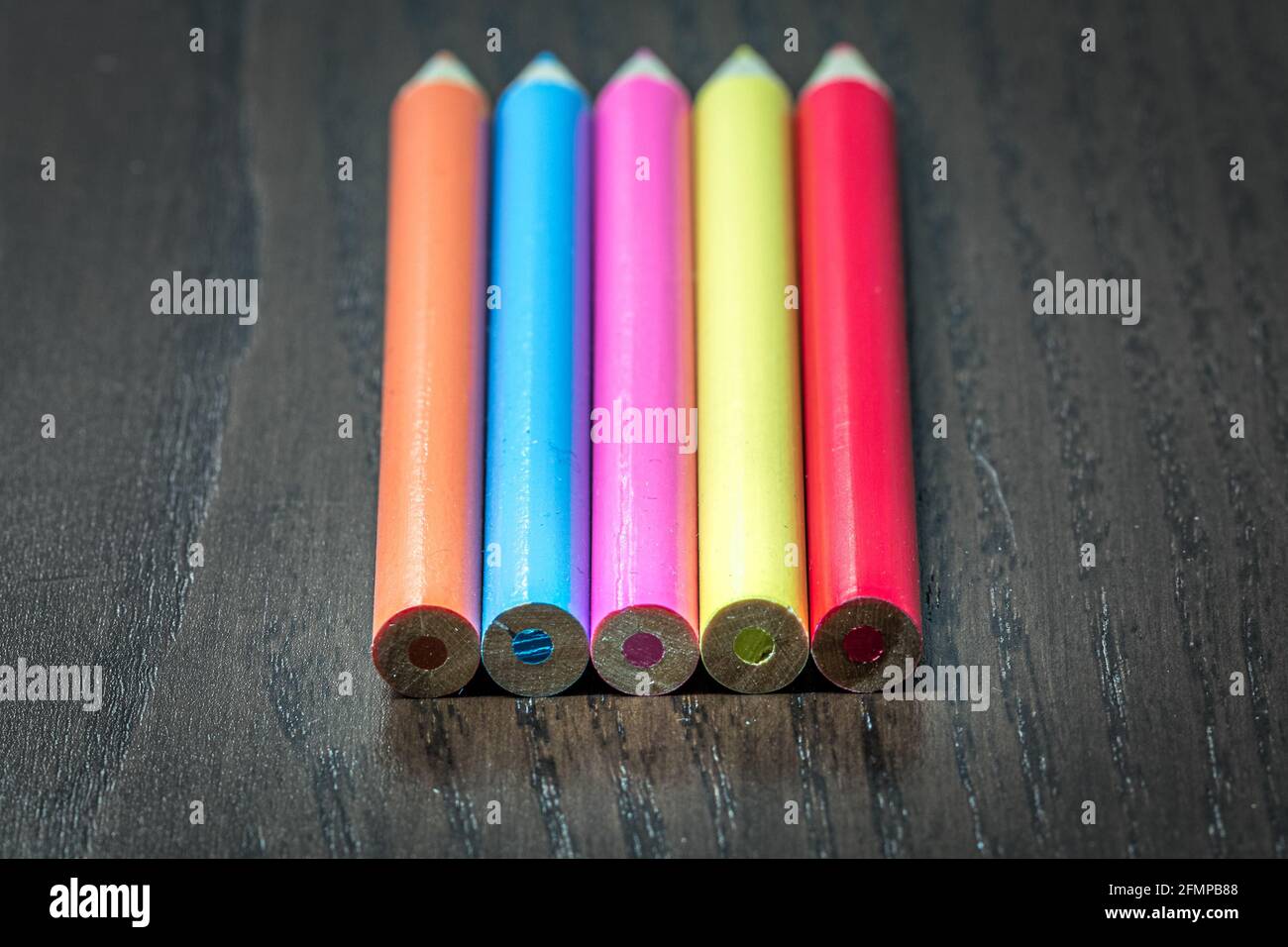 Colored pencils on dark wood Stock Photo - Alamy