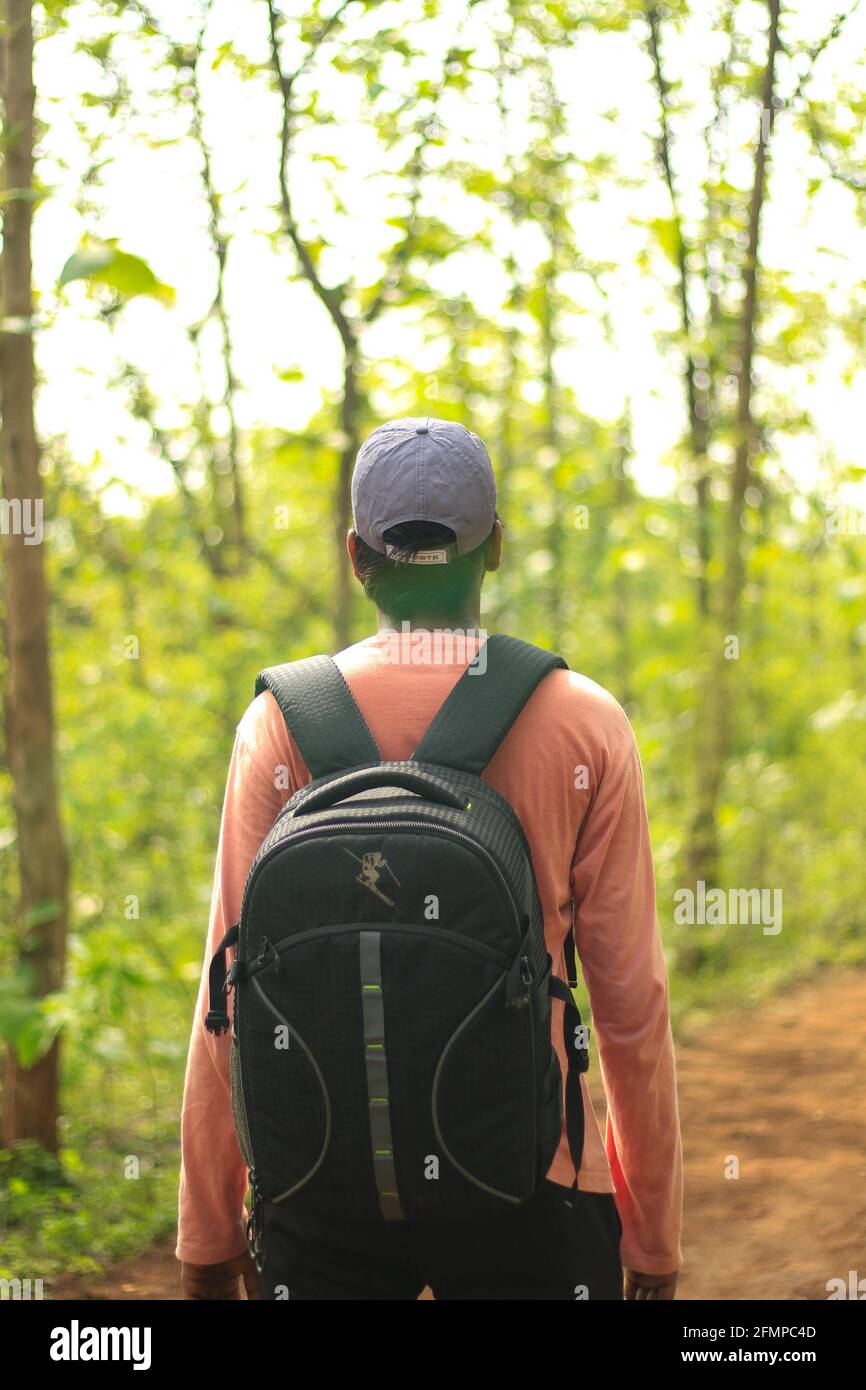 Back side portrait of a young indian man carrying a camera bag and ...