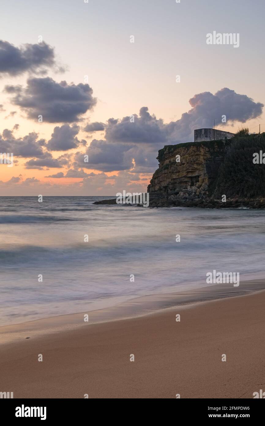 Vertical shot of sandy beach and wavy sea at sunset Stock Photo - Alamy