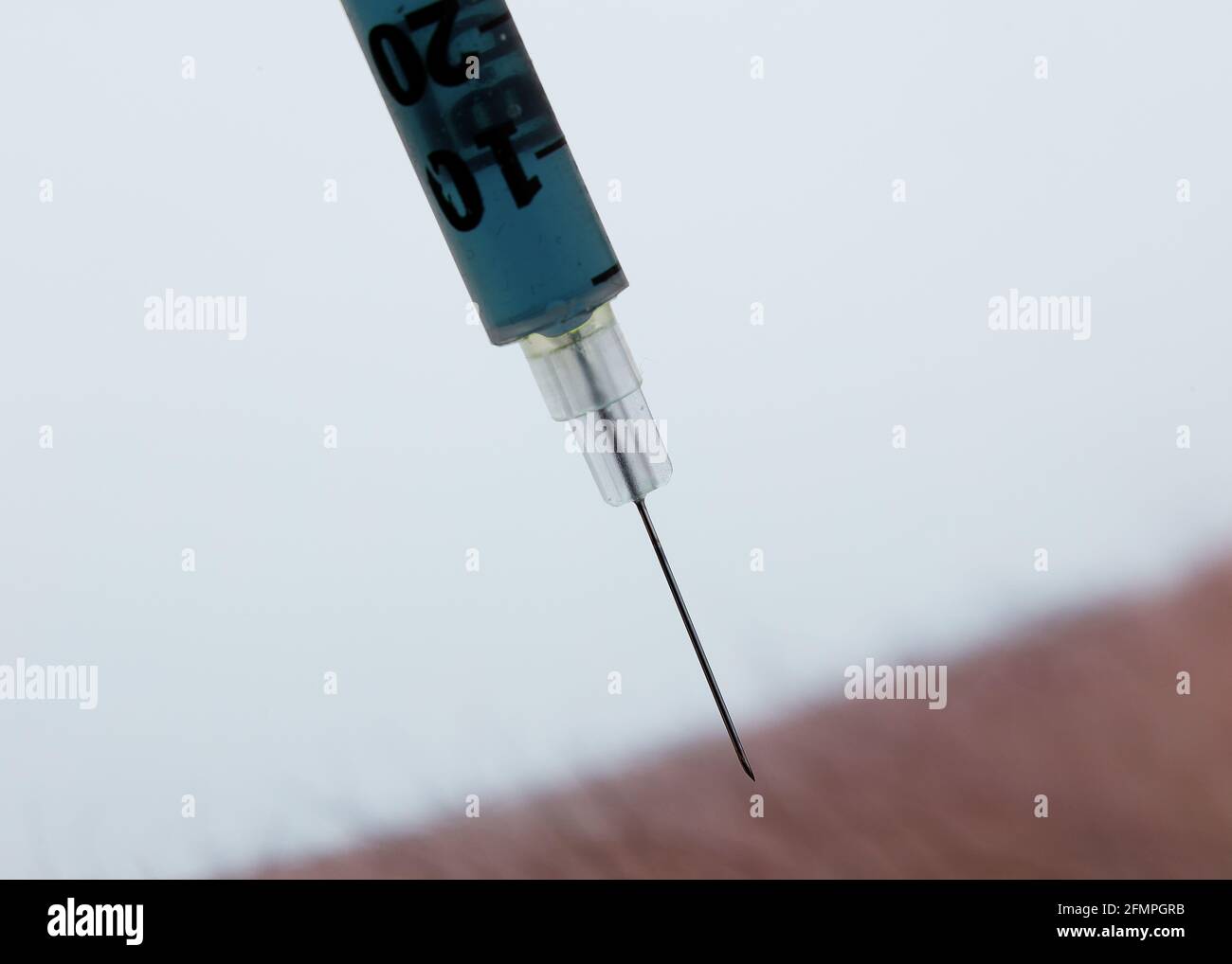 Injection needle about to inject someone Stock Photo - Alamy