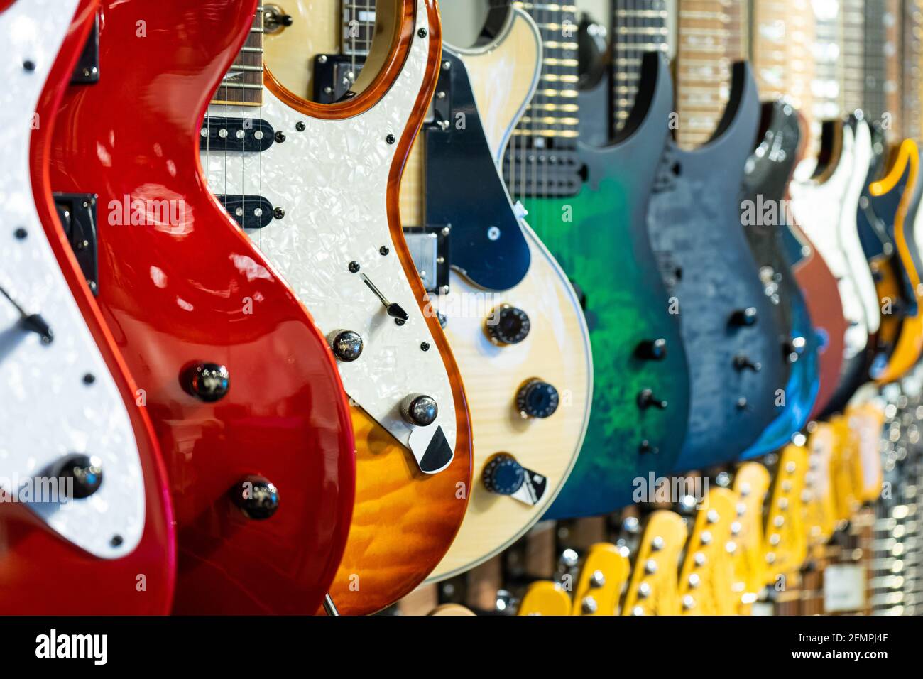 Row of electric guitars different color in a music instruments shop ...