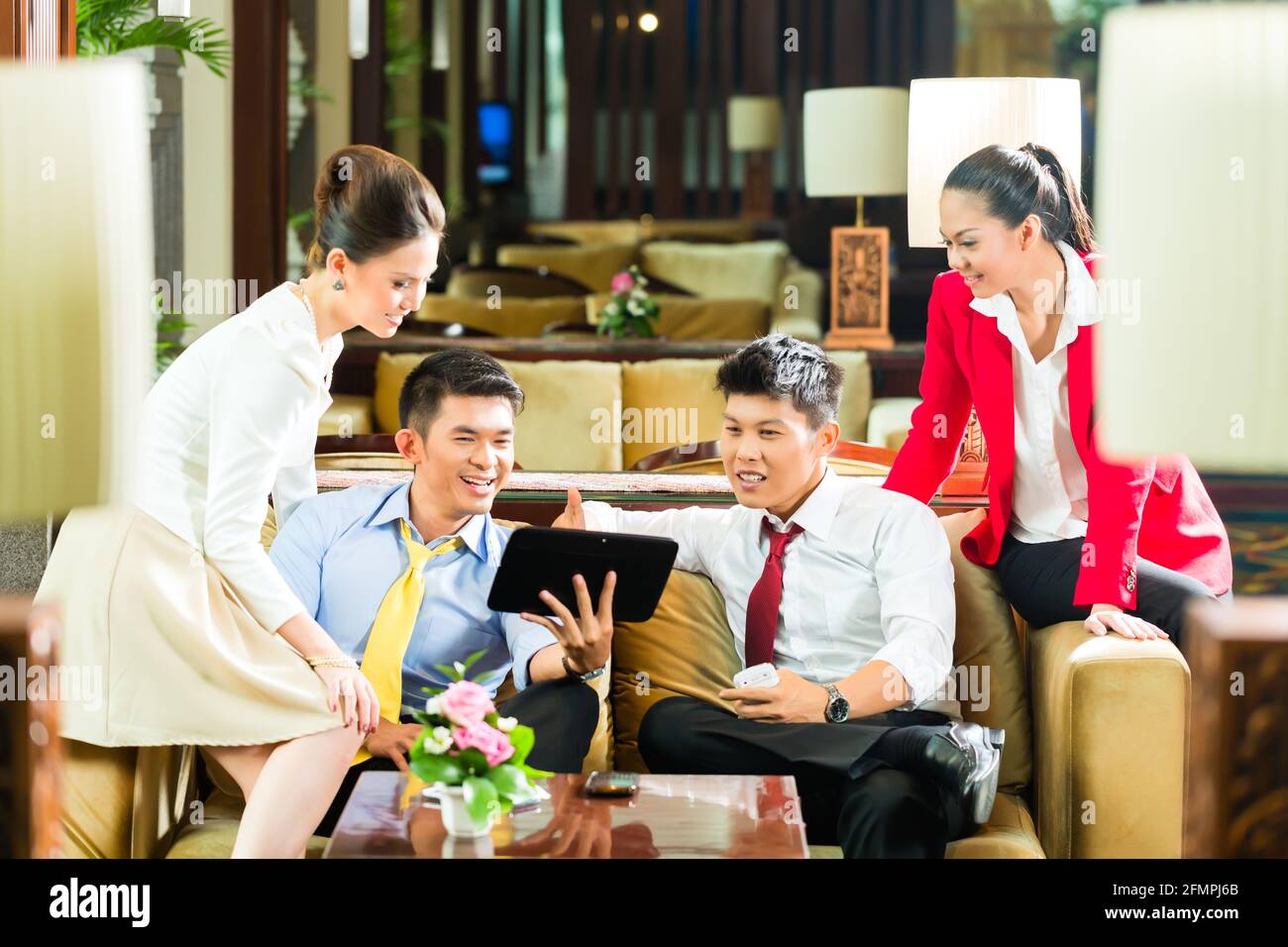 Group of four Asian Chinese businesspeople meeting for small team ...