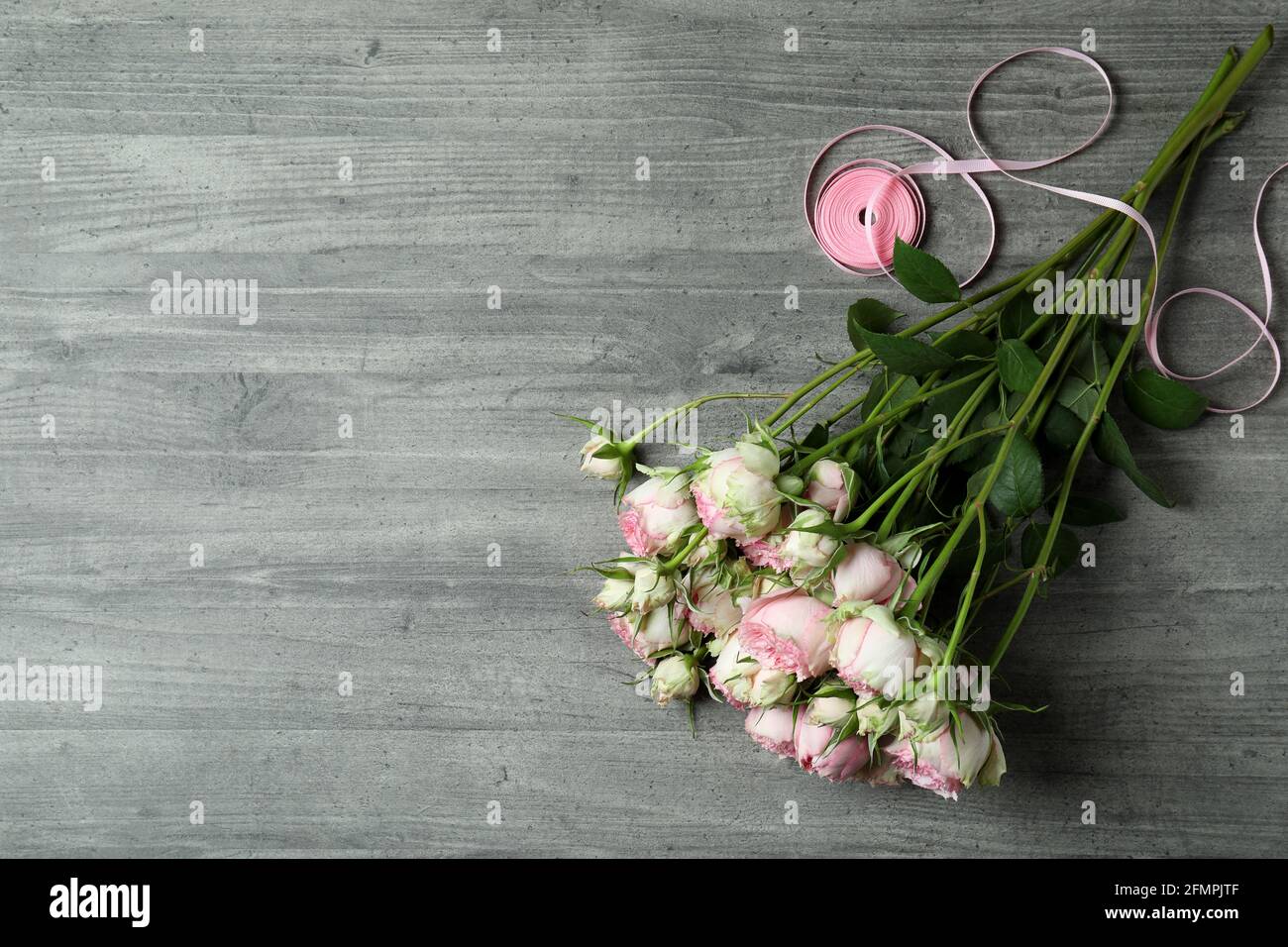 Beautiful rose flowers on gray textured background Stock Photo - Alamy