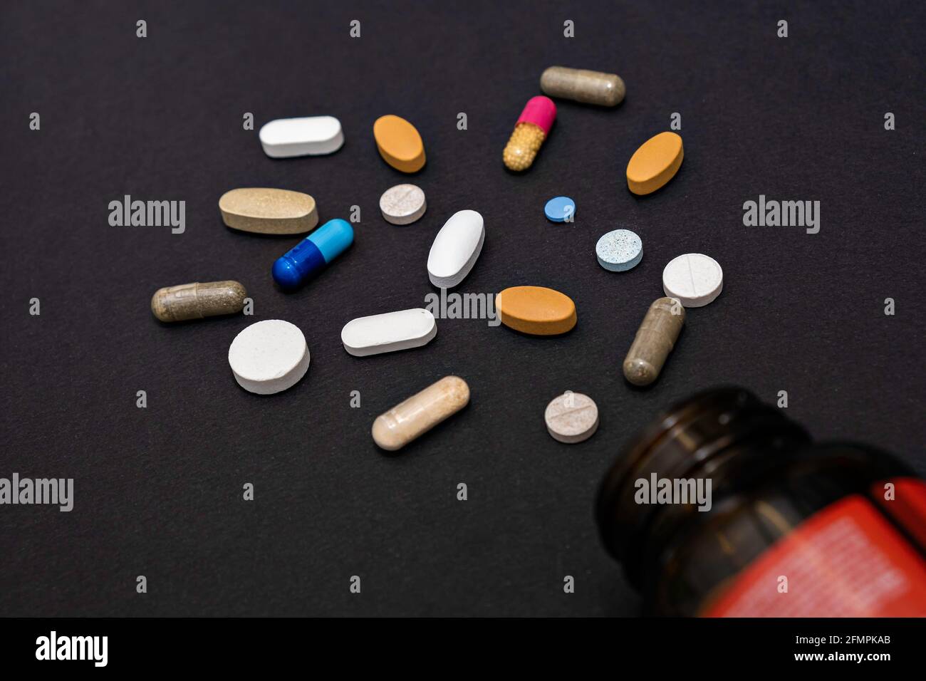 Close-up colorful assorted powder soft capsules pill vitamins and jar ...