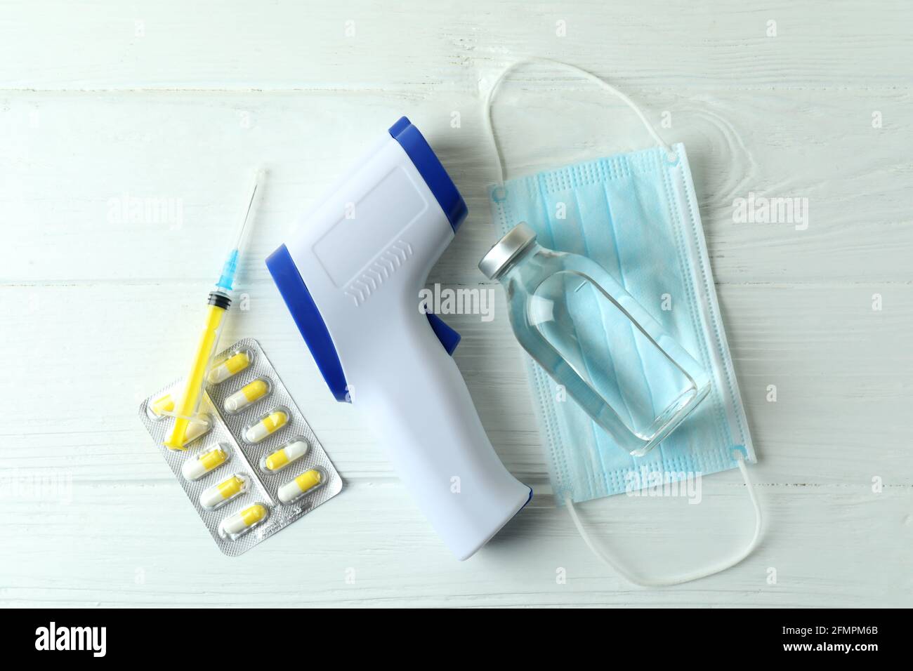 Medical tools and thermometer gun on wooden background Stock Photo - Alamy