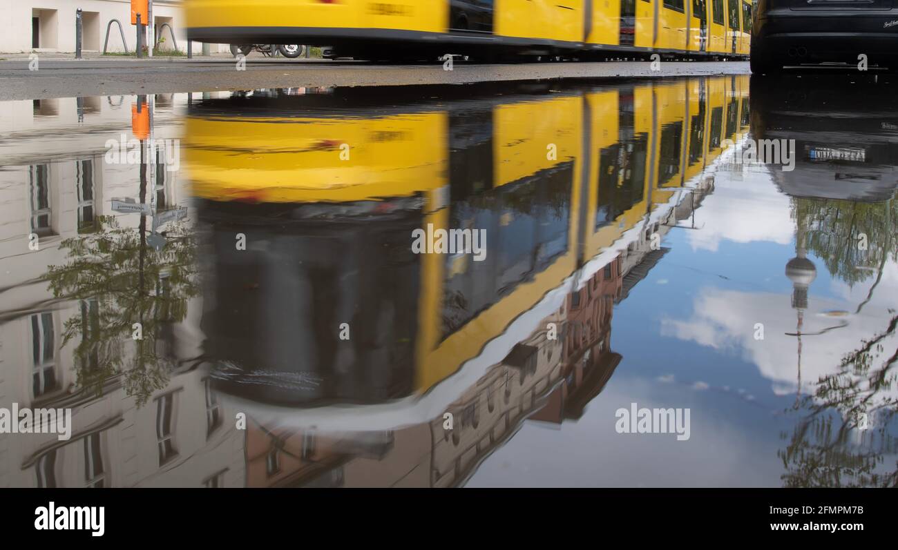 Berlin, Germany. 09th May, 2021. A tram is reflected in a puddle of ...