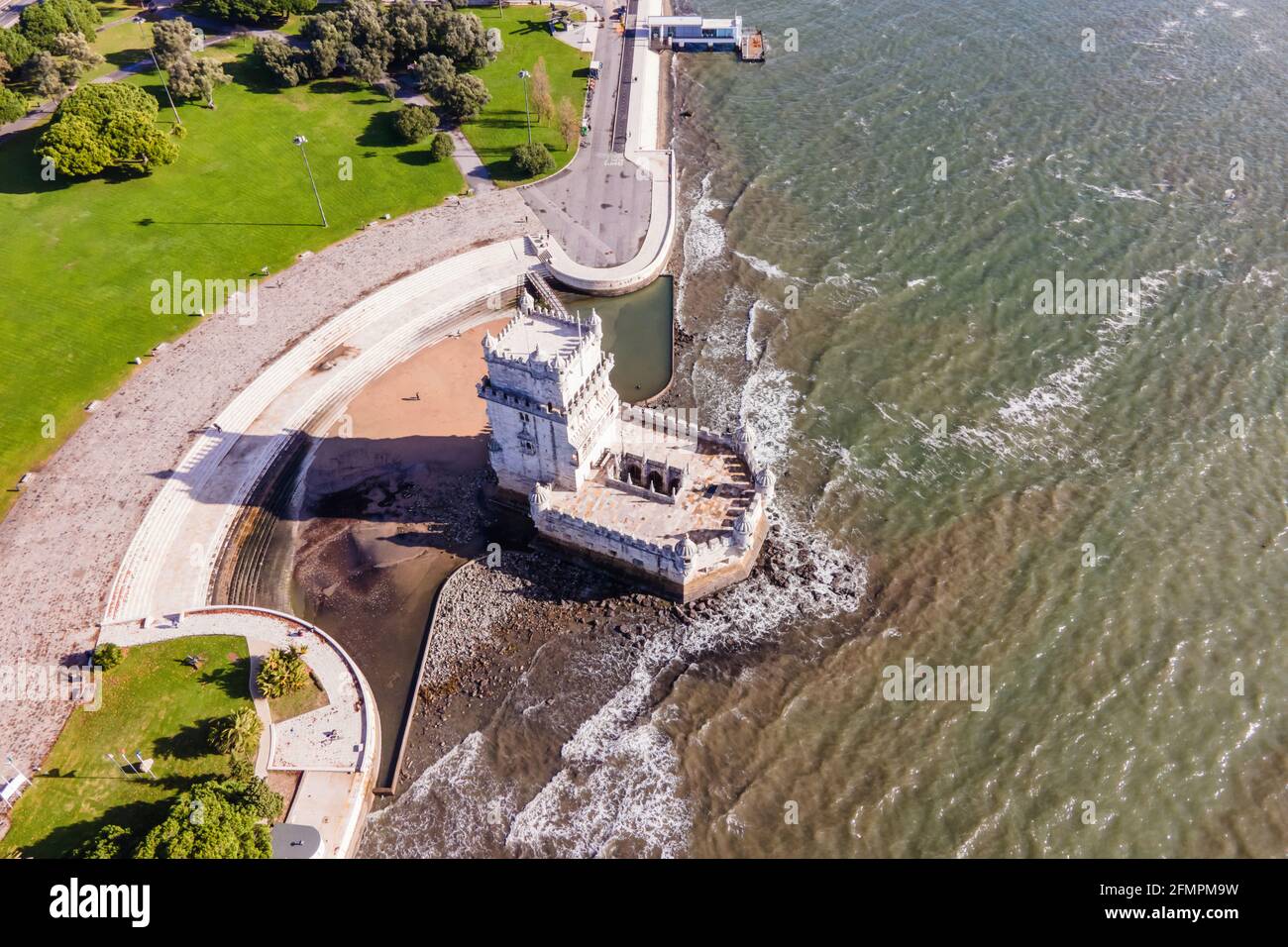 Aerial view of Belem Tower along Tagus River, view of the waves rolling ...