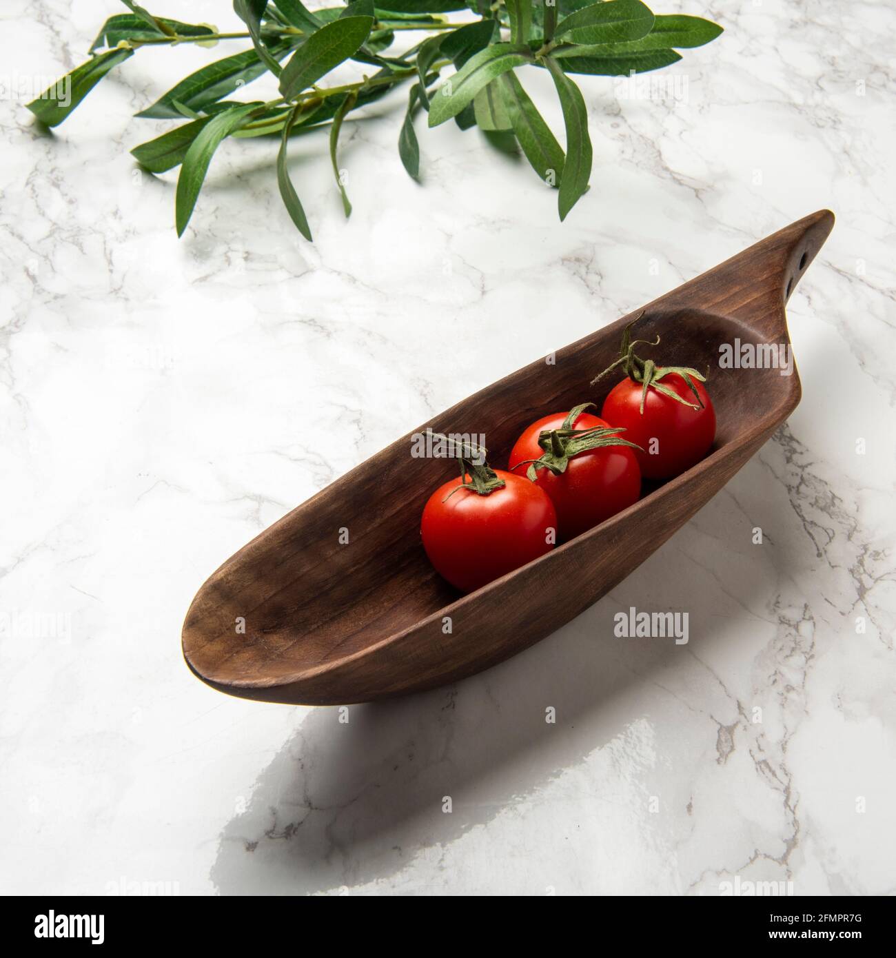 wooden bowl on white marble with little tomatoes Stock Photo - Alamy